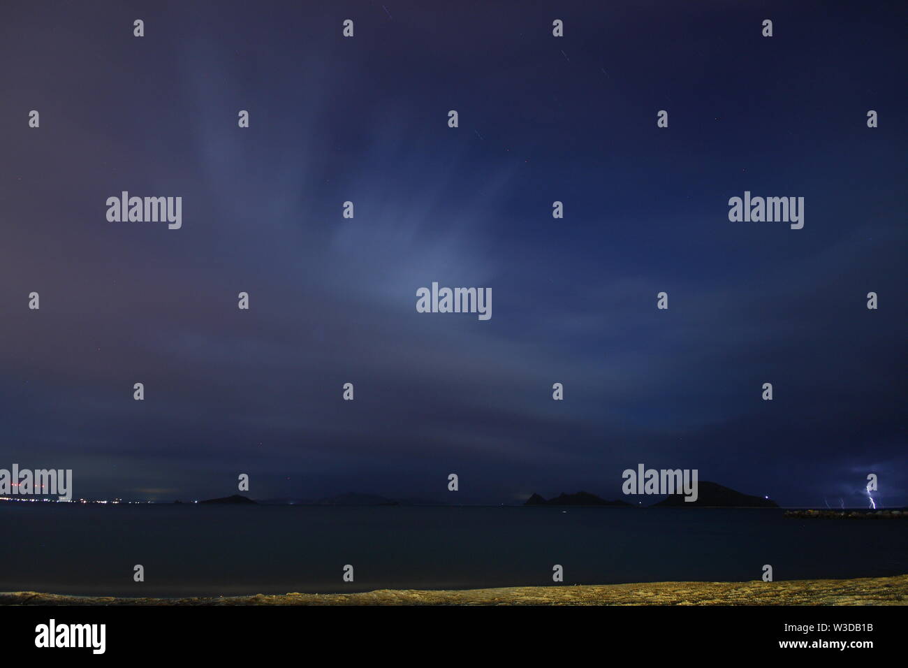 view of lightning strike over a rural farm field, lightning strikes the ...