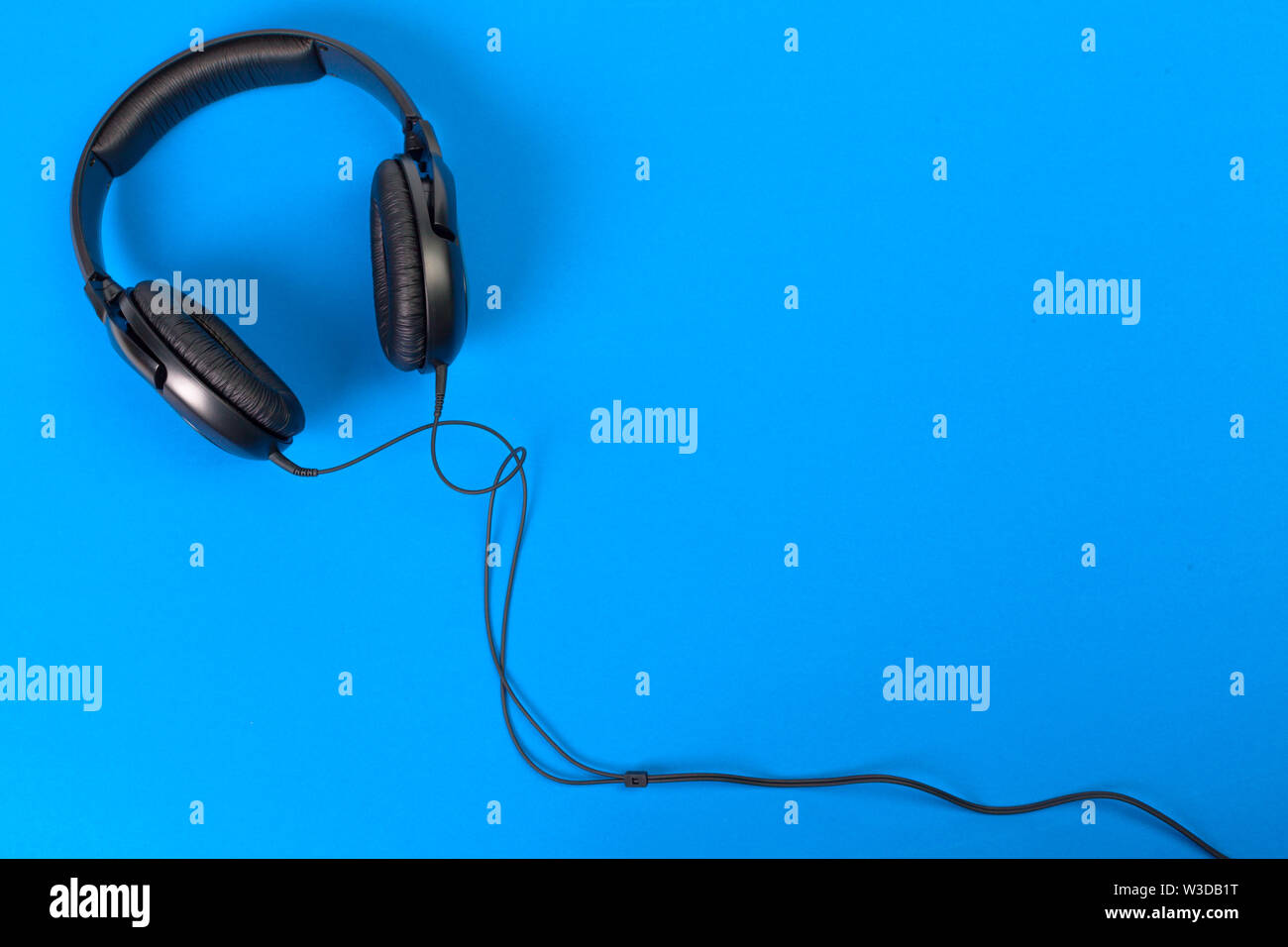 Headphones on blue background Stock Photo - Alamy