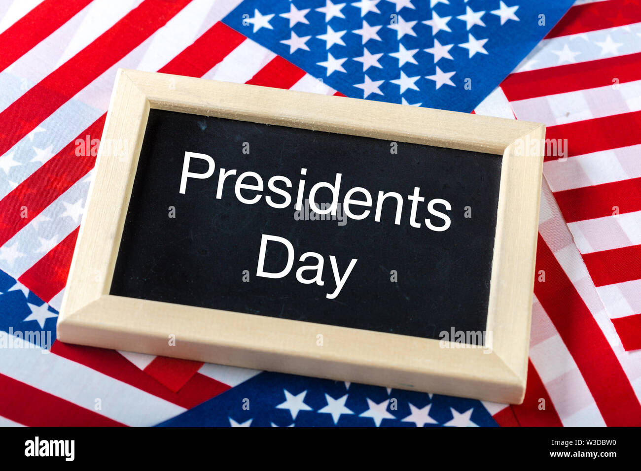 the text happy presidents day written in a chalkboard and a flag of the ...