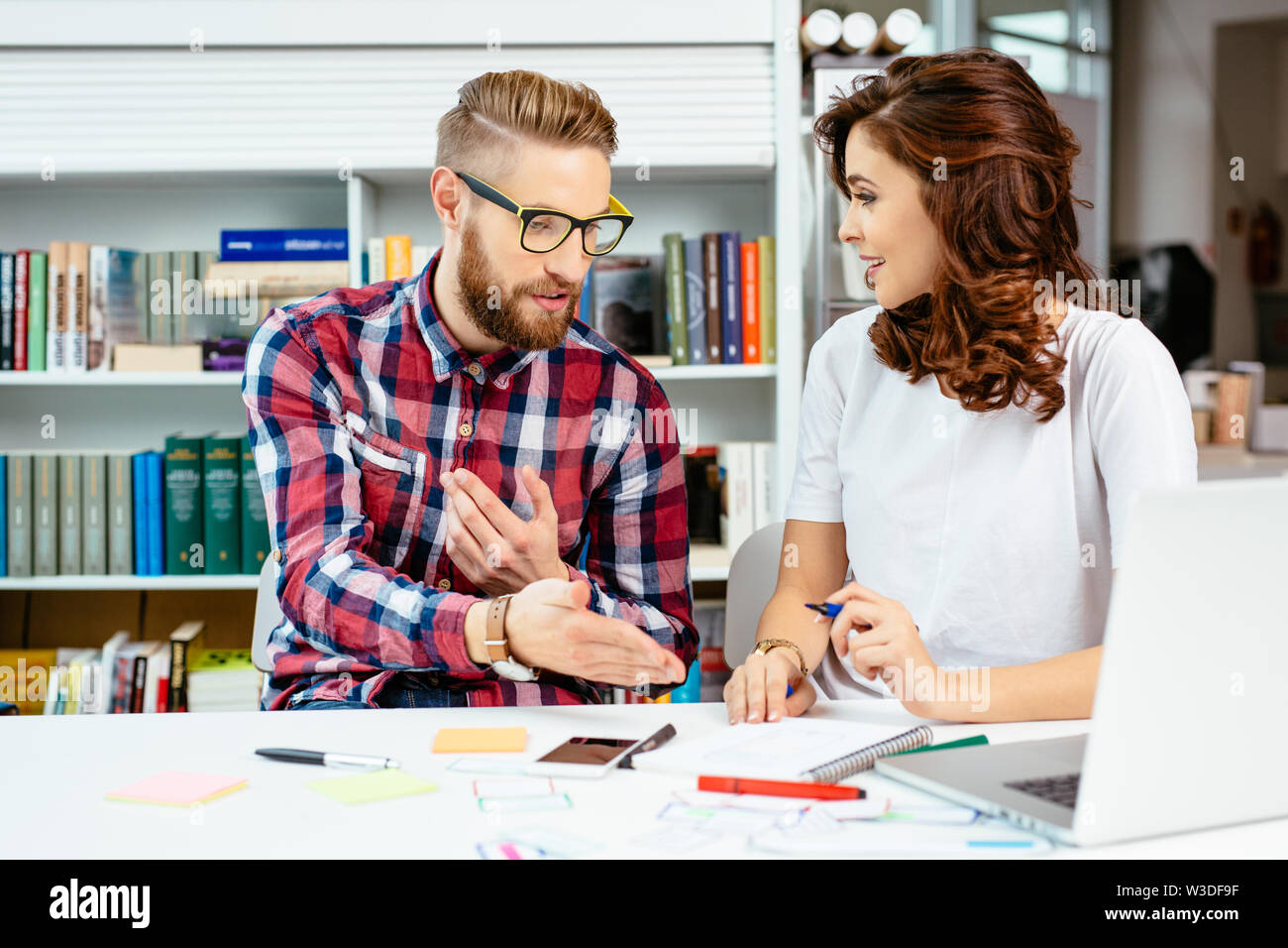 Coworkers sharing their knowledge at modern office during business ...