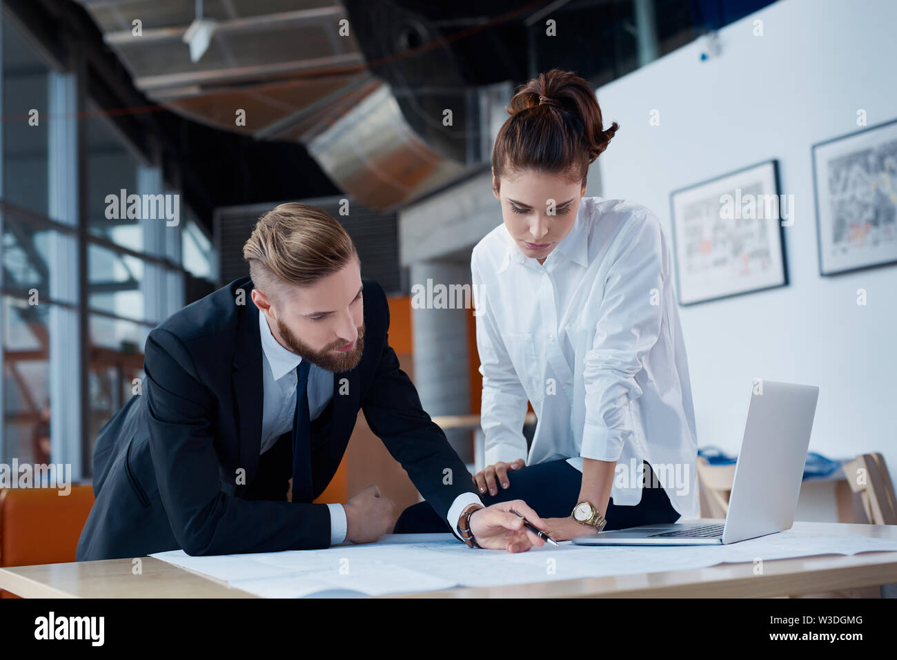 Busy architects at office working on construction plan Stock Photo - Alamy