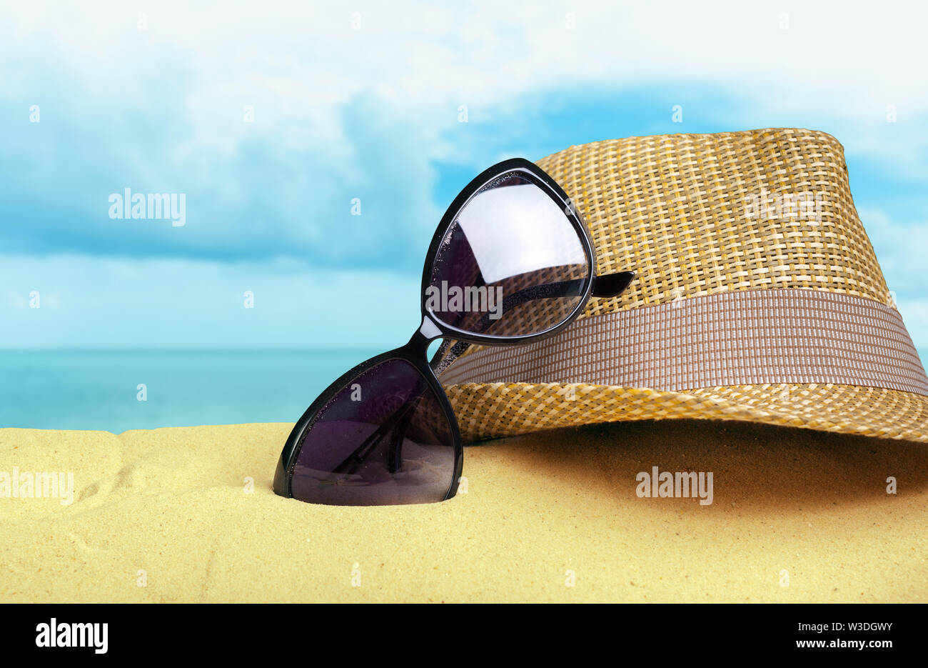 straw hat on beach sand Stock Photo - Alamy
