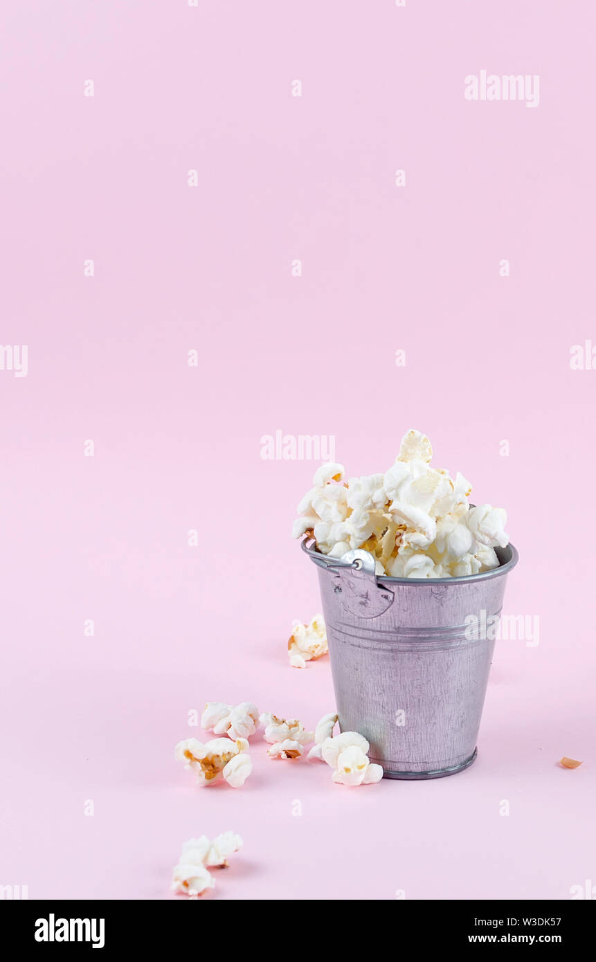Popcorn in a bucket at the pastel pink background and a space for ...