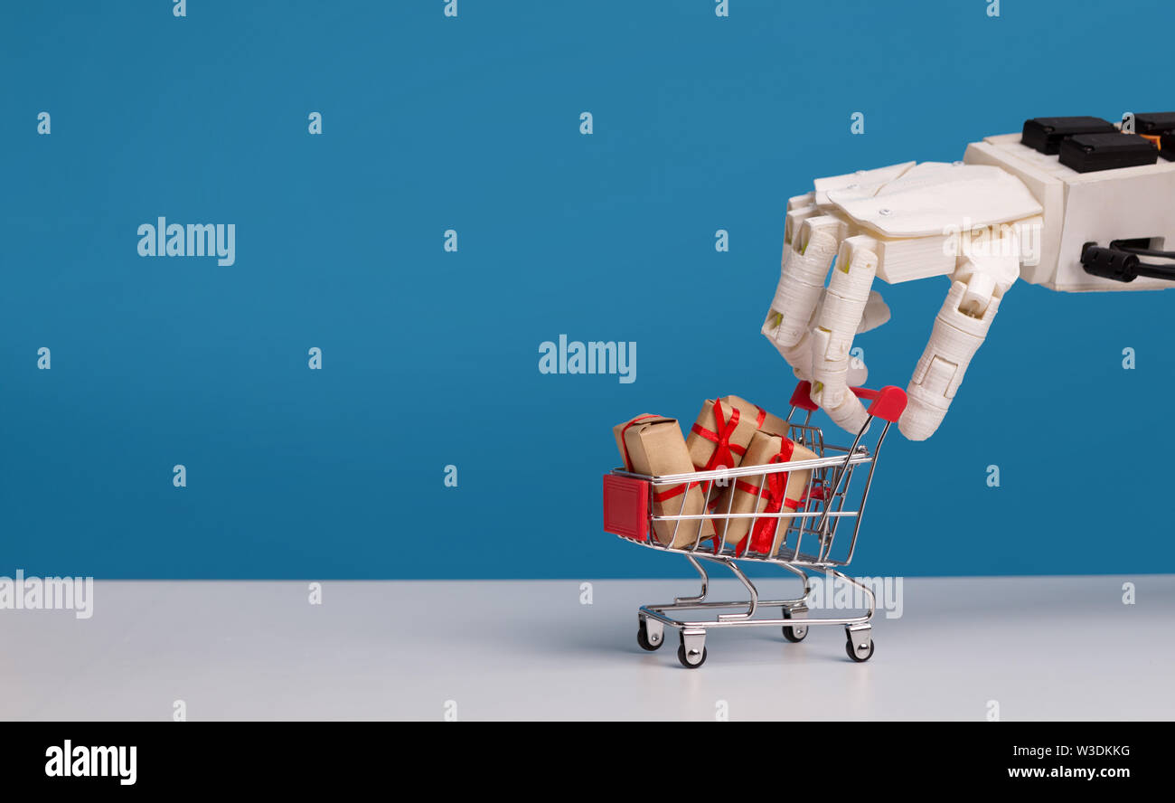Robot hand holding shopping cart with gift boxes Stock Photo - Alamy