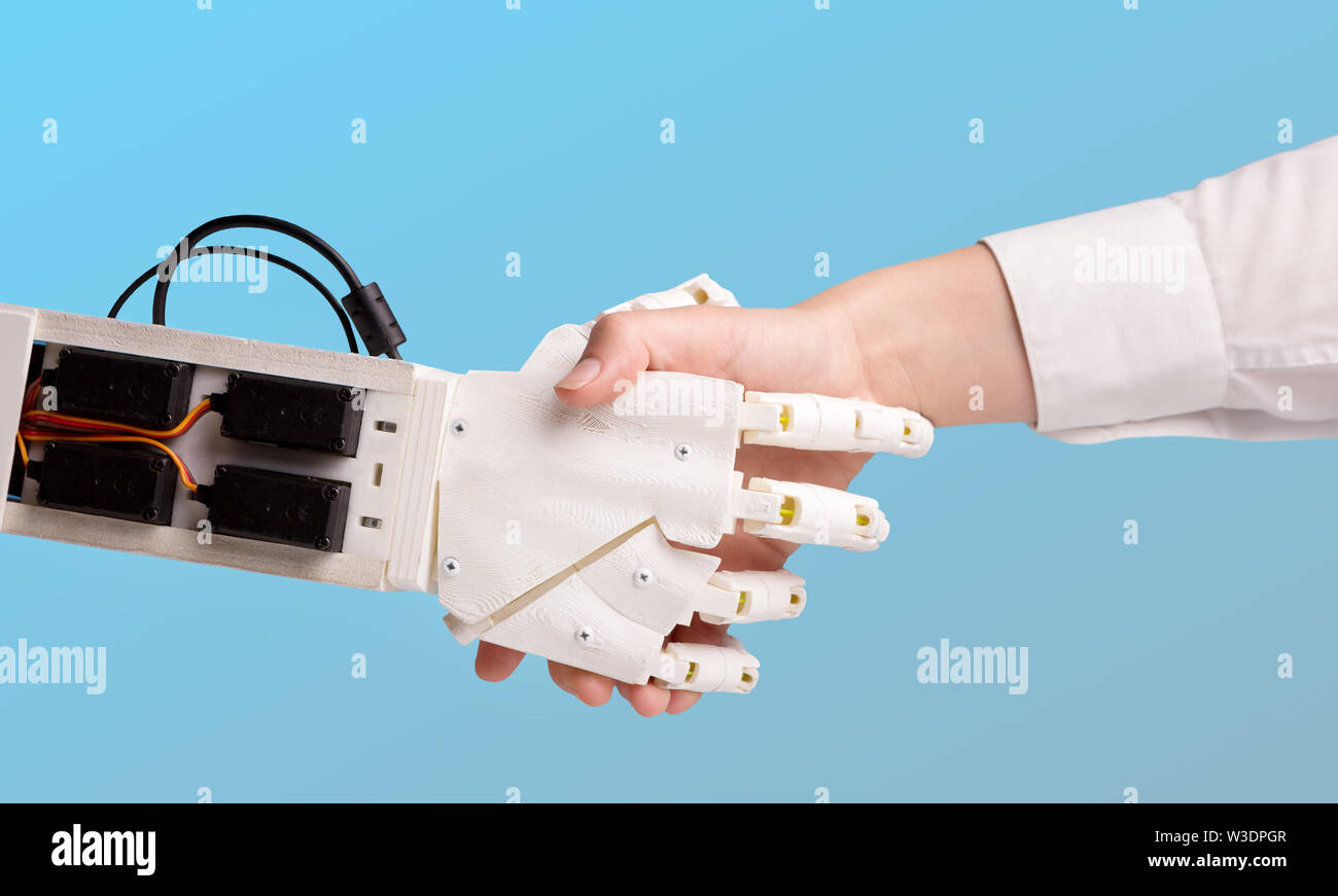 Robot and human holding hands with handshake Stock Photo - Alamy