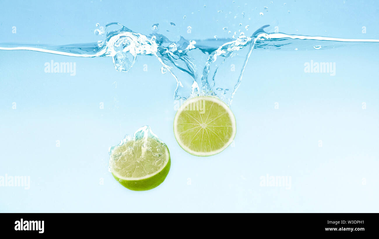 Cut lime falling deeply under water with splash Stock Photo - Alamy
