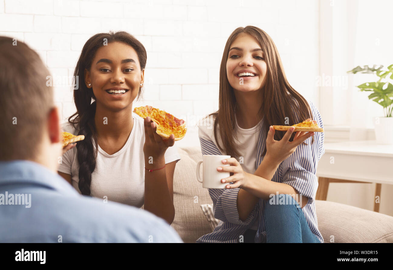 Students eating pizza and talking at home Stock Photo - Alamy