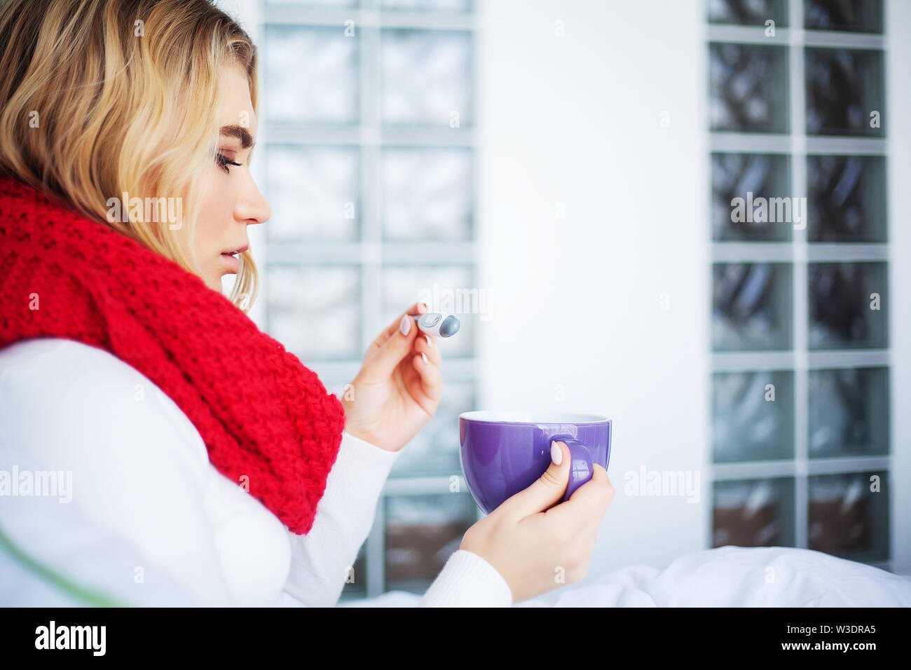Sick woman in bed with thermometer is having high temperature fever ...