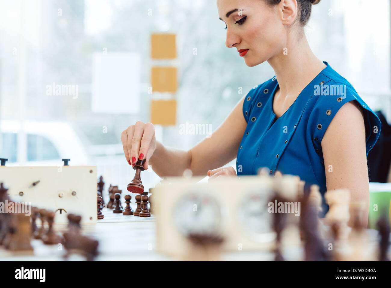 Woman playing chess in tournament Stock Photo - Alamy