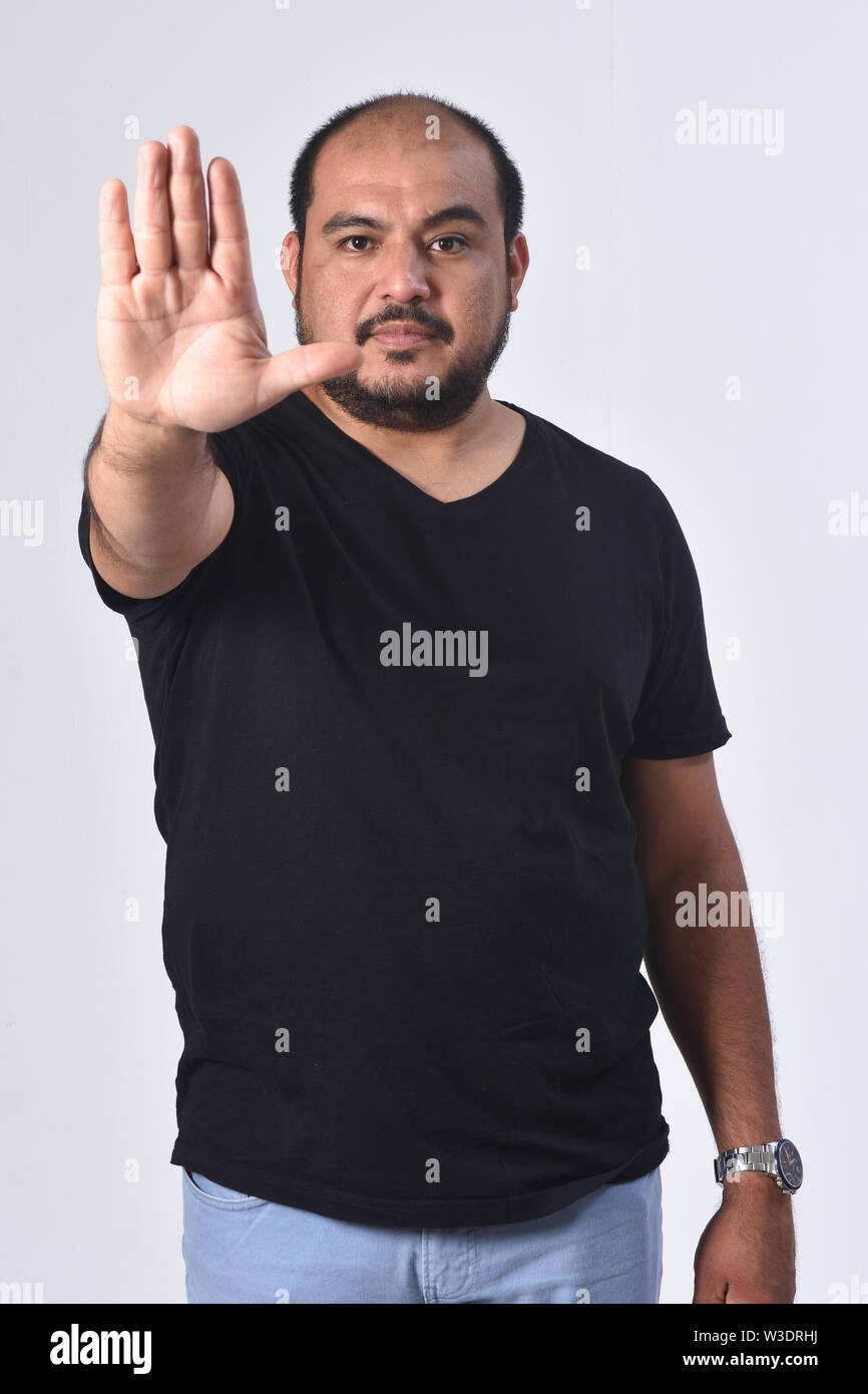 Latin american Man with stop sign white background Stock Photo - Alamy
