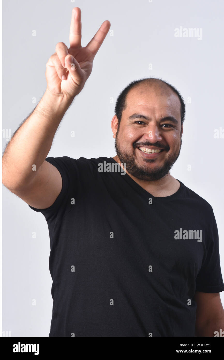Latin american man making the victory sign on a white background Stock ...