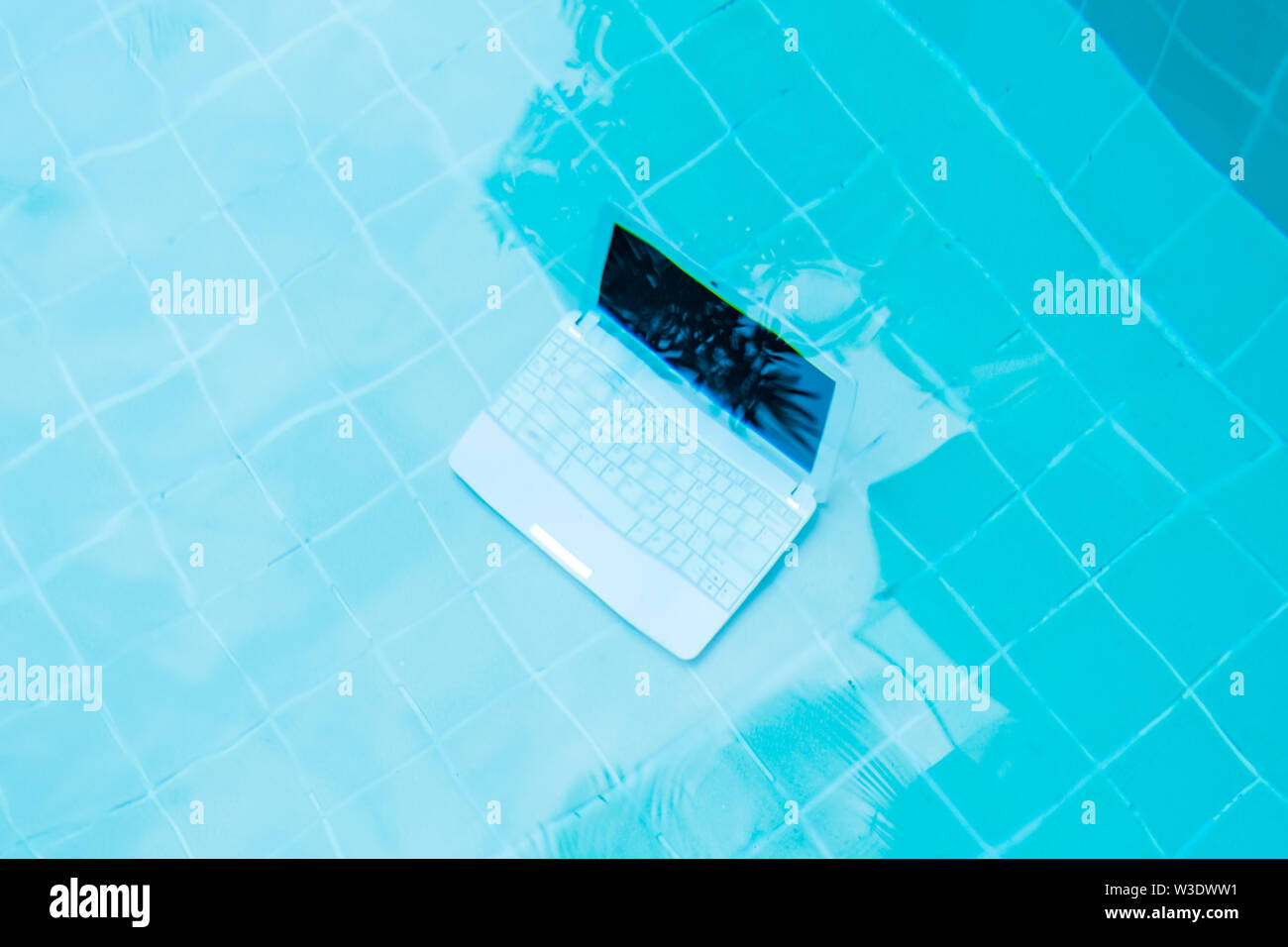 Laptop under water. Minicomputer at the bottom of the pool. The concept ...