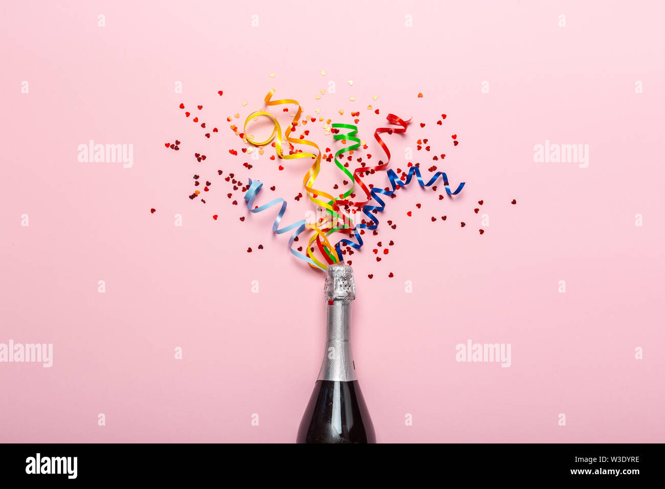 Champagne bottle with colorful party streamers Stock Photo - Alamy