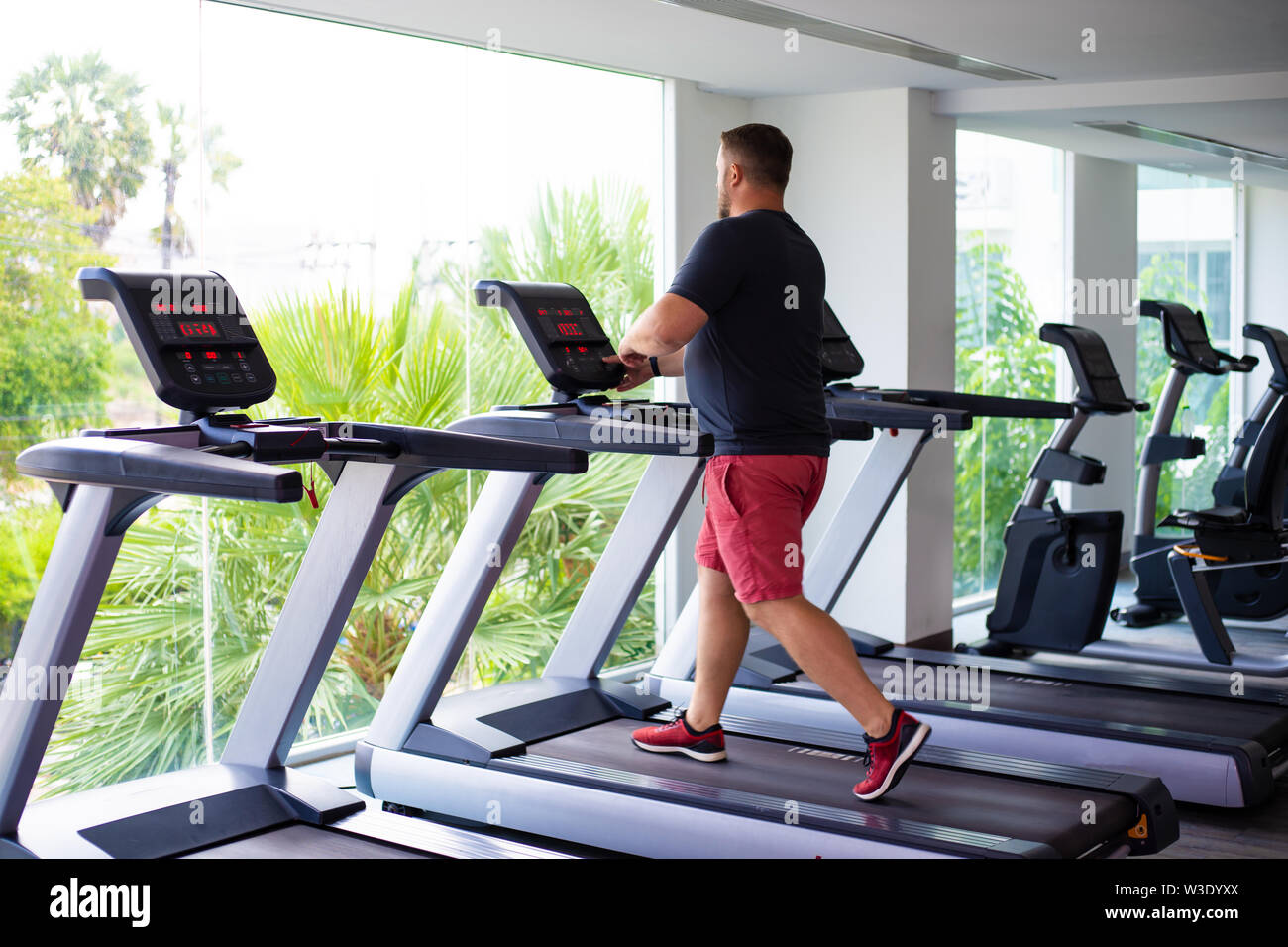 full male runs on a treadmill in a gym. concept of weight loss and ...