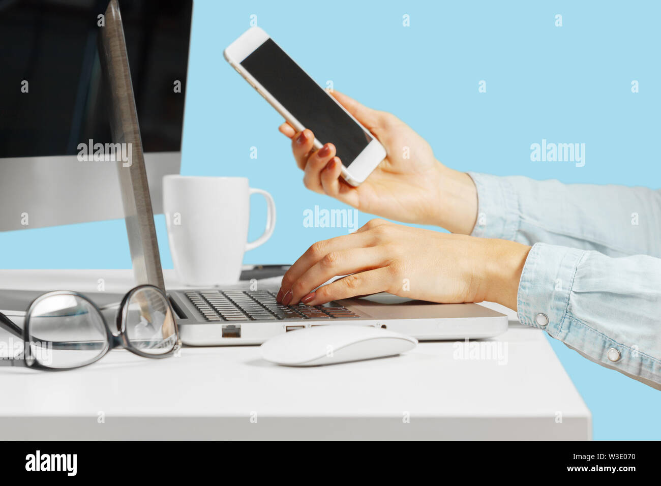 Young woman sitting at the table with open netbook computer. Female ...