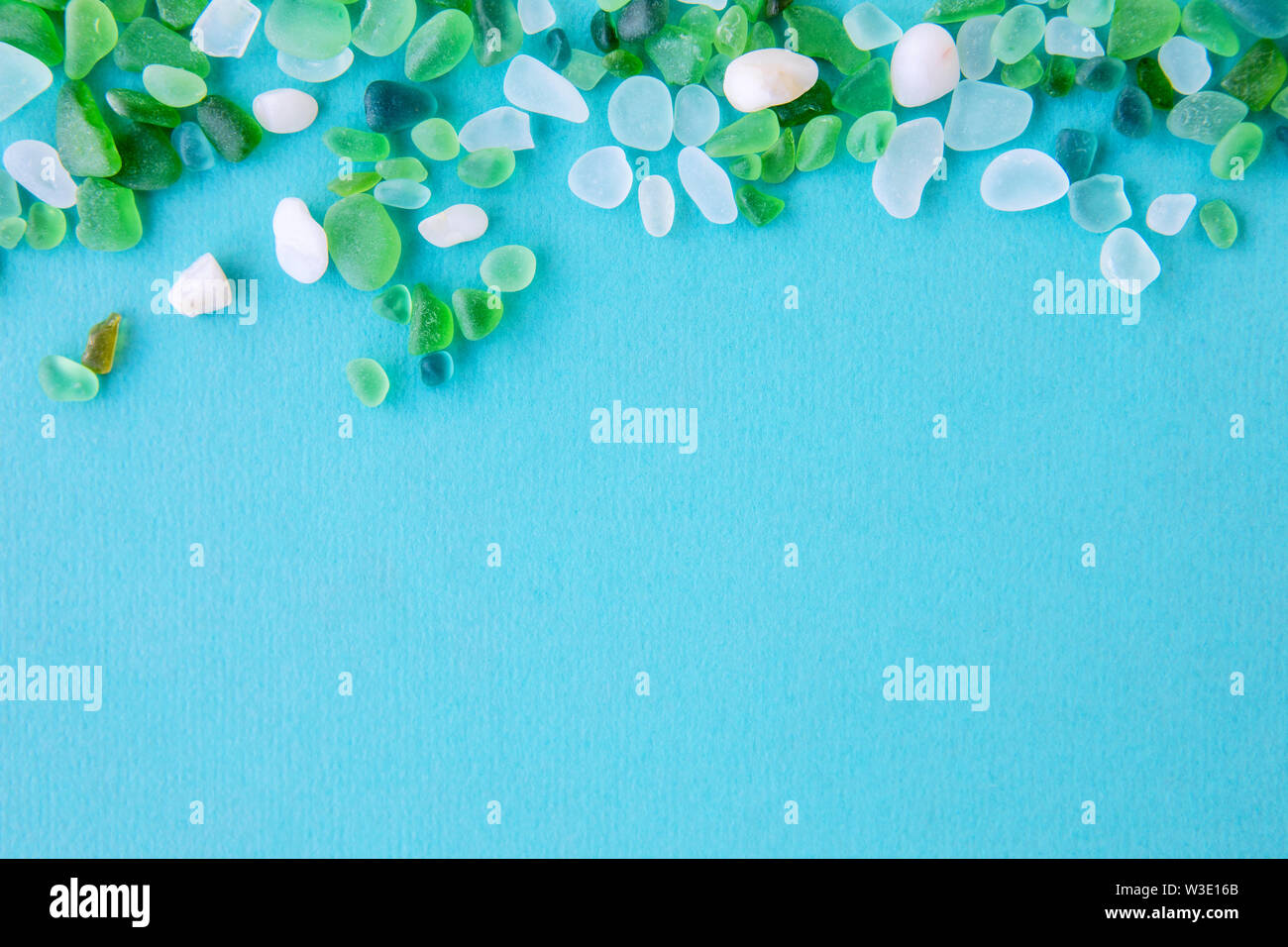 Close up of various sea glass pieces on blue background. Design ...