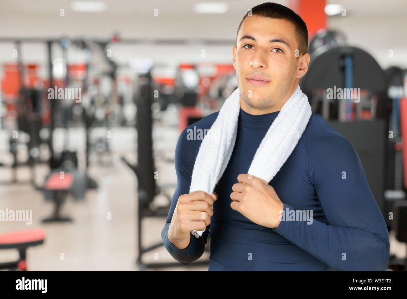 Portrait of a smiling guy at the gym to stay fit and having defined ...