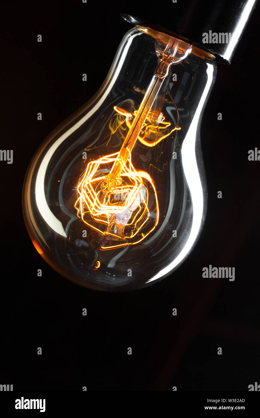 A classic Edison light bulb on dark background with space for text ...