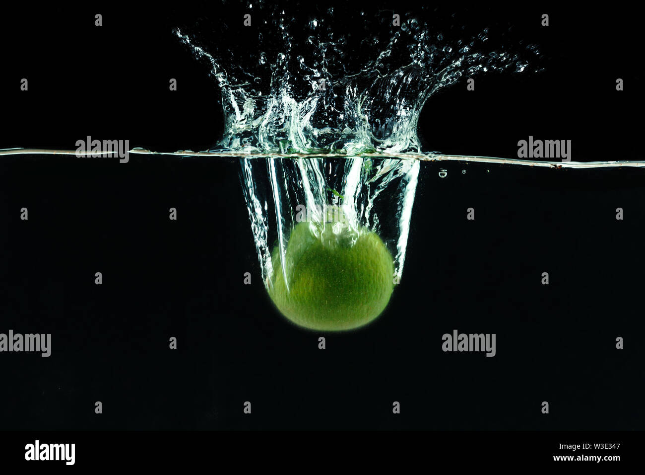 Fresh lime dropped into water with splash Stock Photo - Alamy