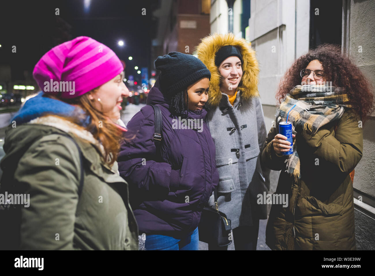group of young women standing in the street and having conversation ...
