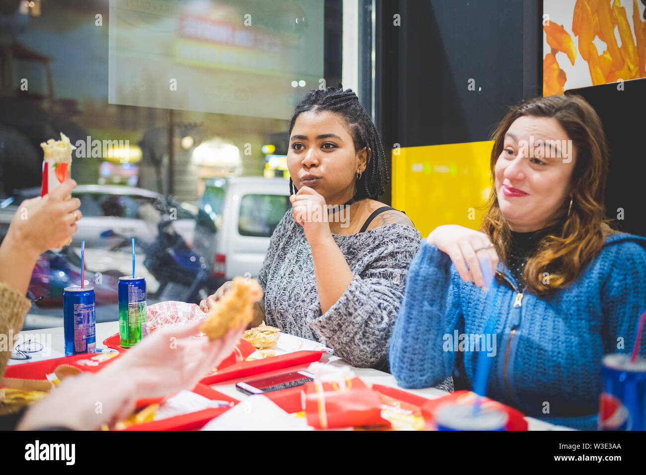 group of young girlfriends having meal in fast food – hungry, union ...