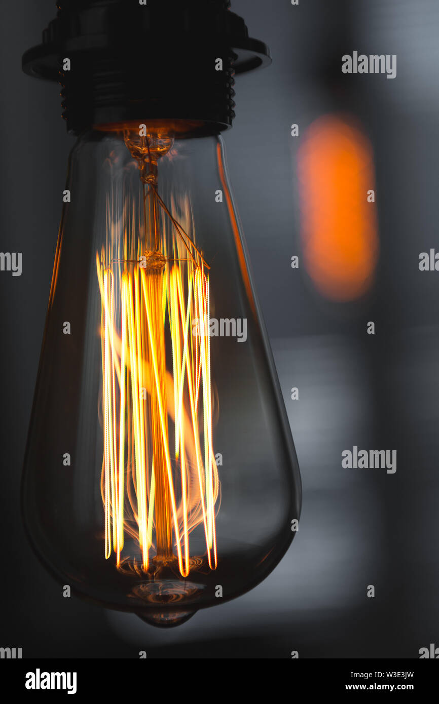 A classic Edison light bulb on dark background with space for text ...