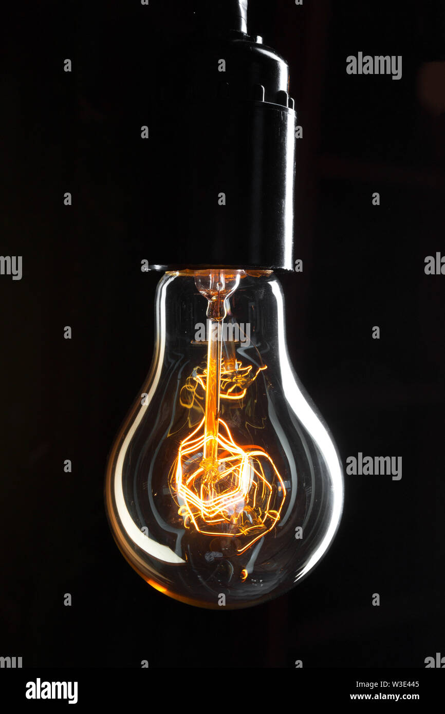 A classic Edison light bulb on dark background with space for text ...
