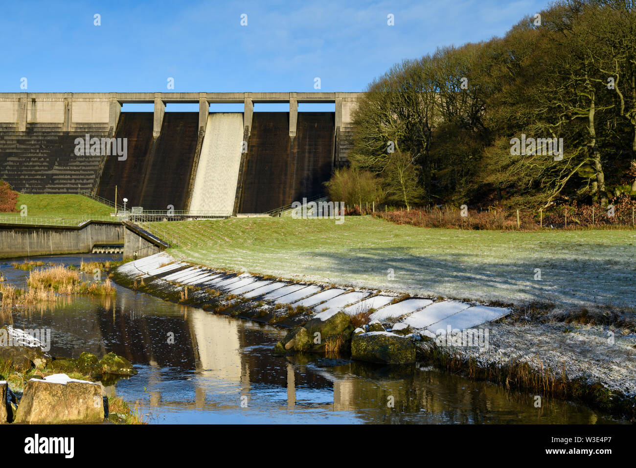 High, steep, concrete dam at Thruscross Reservoir reflected in water ...