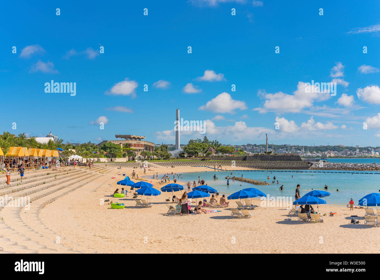 Beach umbrellas and palm trees on the Sunset beach in Chatan City in ...