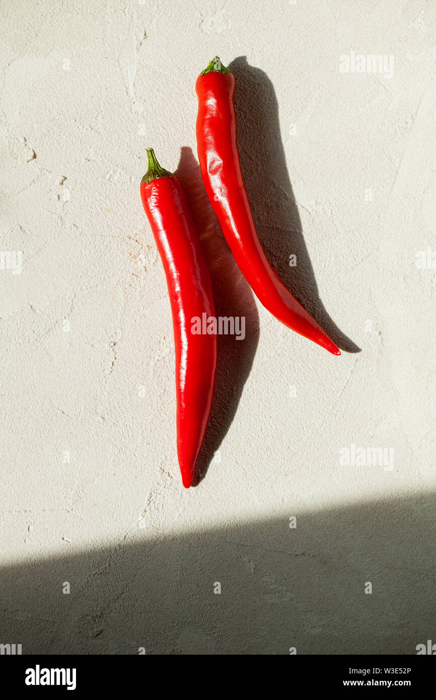 Red hot chili peppers long pods is dried on a white plaster textured ...