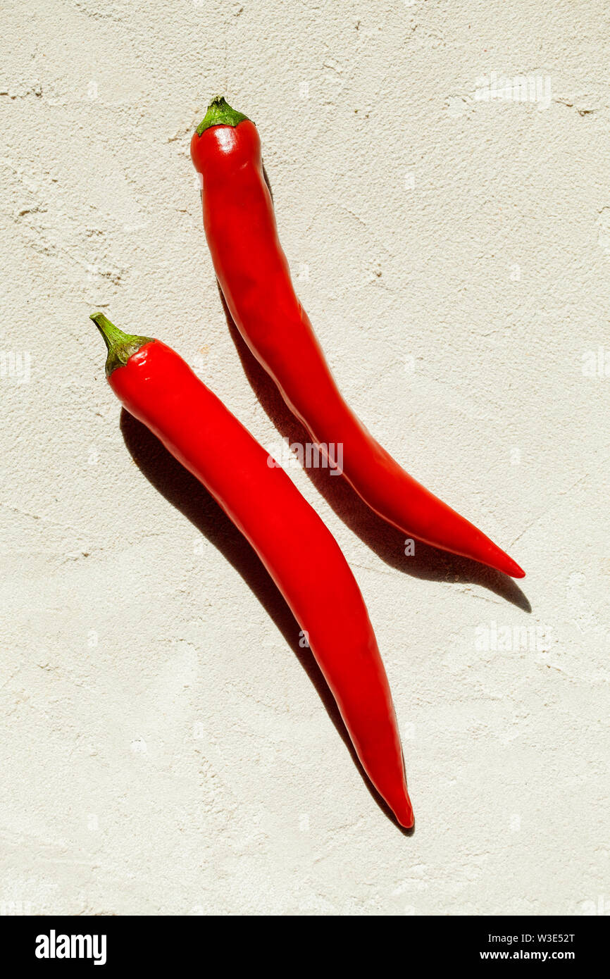 Red hot chili peppers long pods is dried on a white plaster textured ...