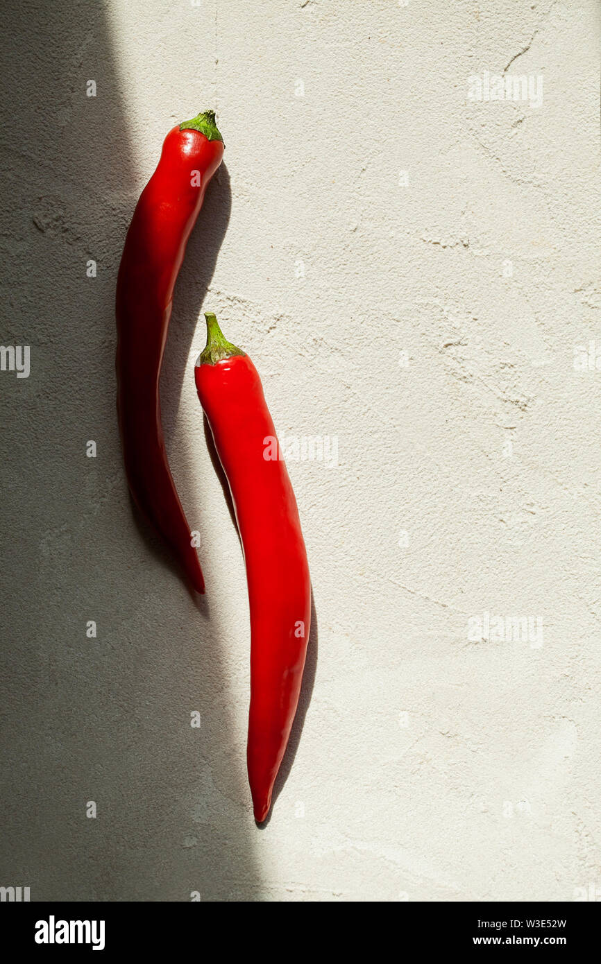 Red hot chili peppers long pods is dried on a white plaster textured ...
