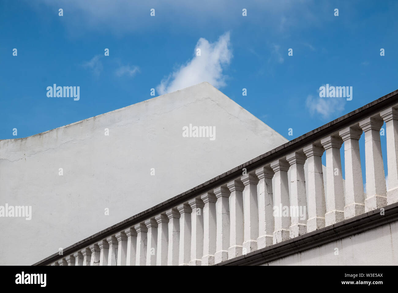 Diagonal line of the fence of a roof terrace. In the background white ...