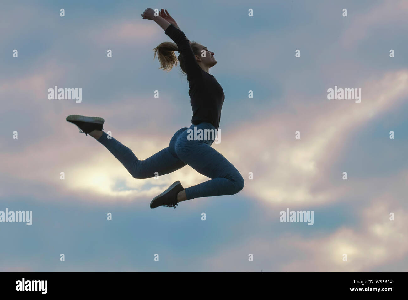 Cheerful Positive Girl Jumping in the Air Outdoor Morning Clouds ...