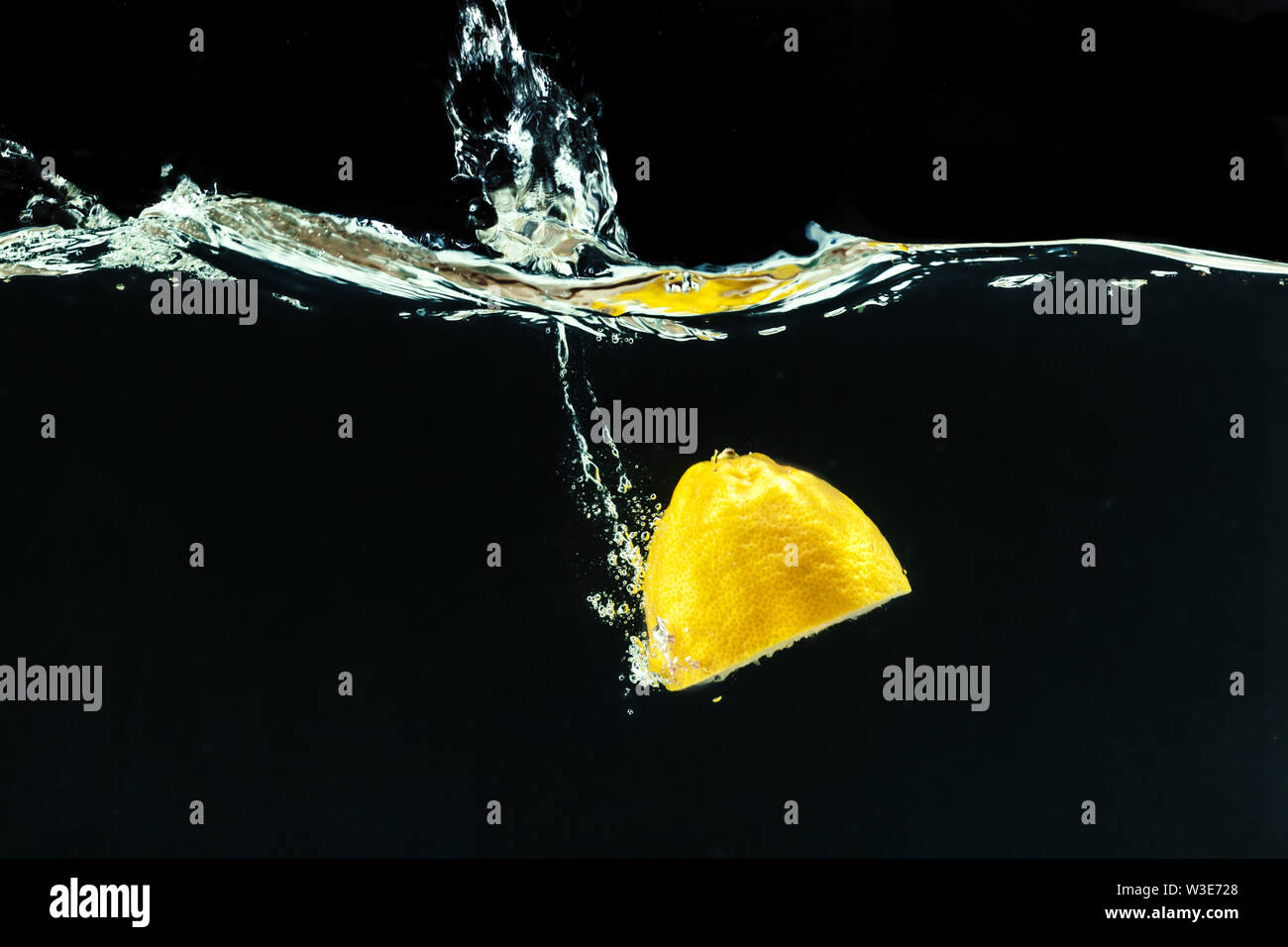 fresh yellow lemon in water splash on black background Stock Photo - Alamy