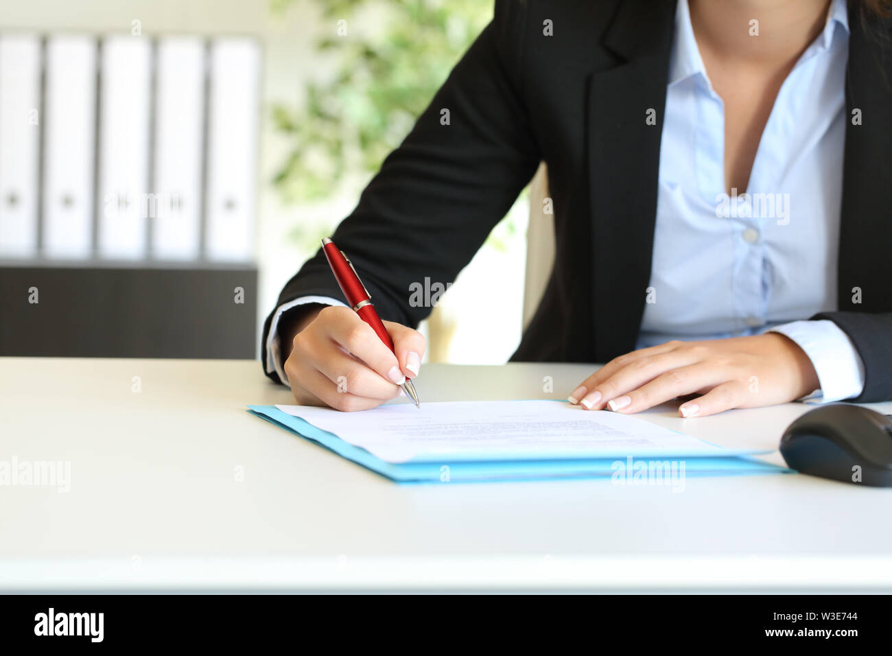 Close up of a businesswoman hands signing a contract on a desktop at ...