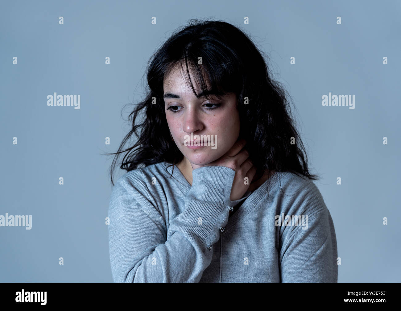 Close up portrait of beautiful young woman with sad eyes looking desperate and melancholy. Human ...