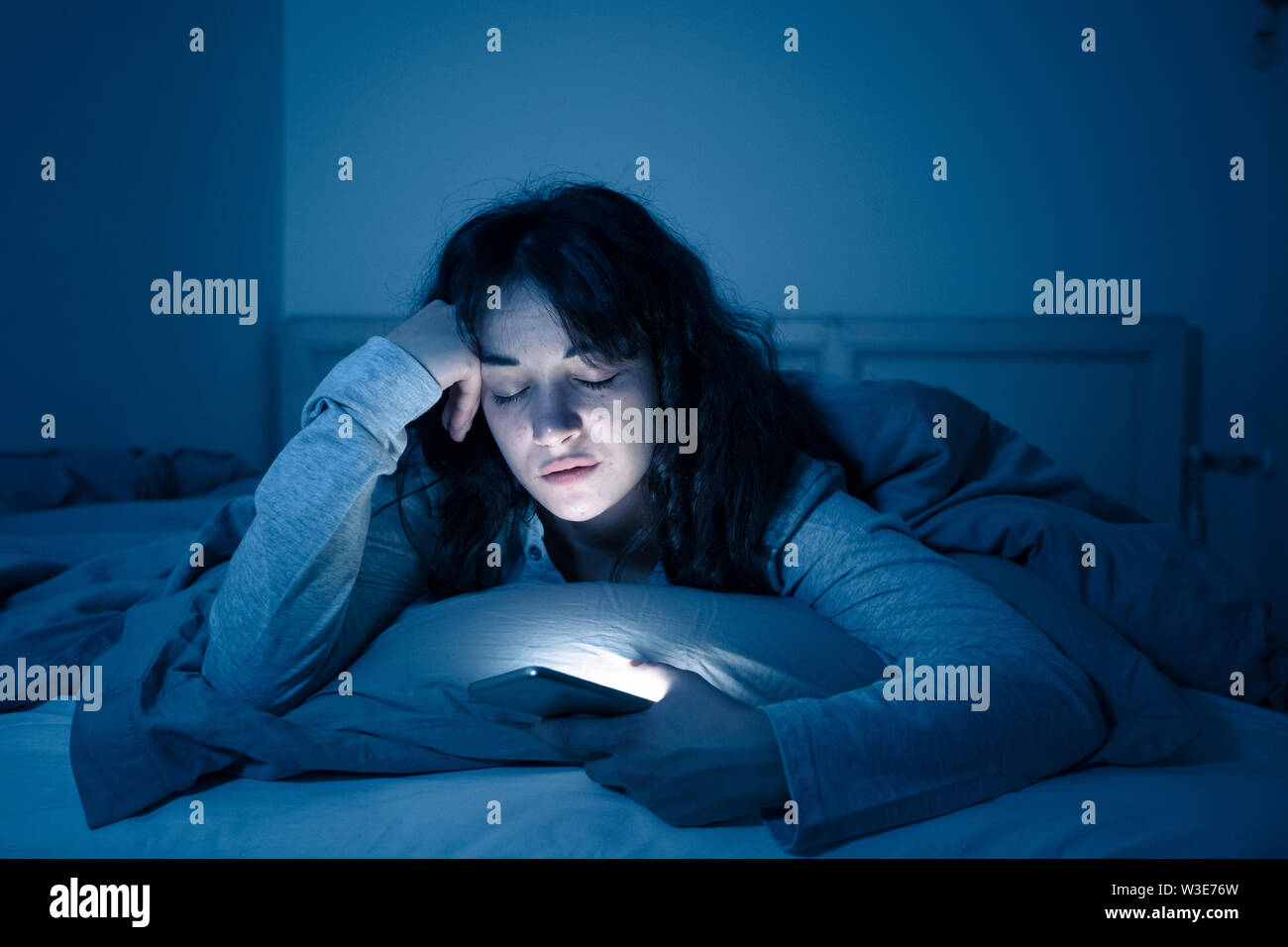 Addicted young woman chatting and surfing on the internet using her ...