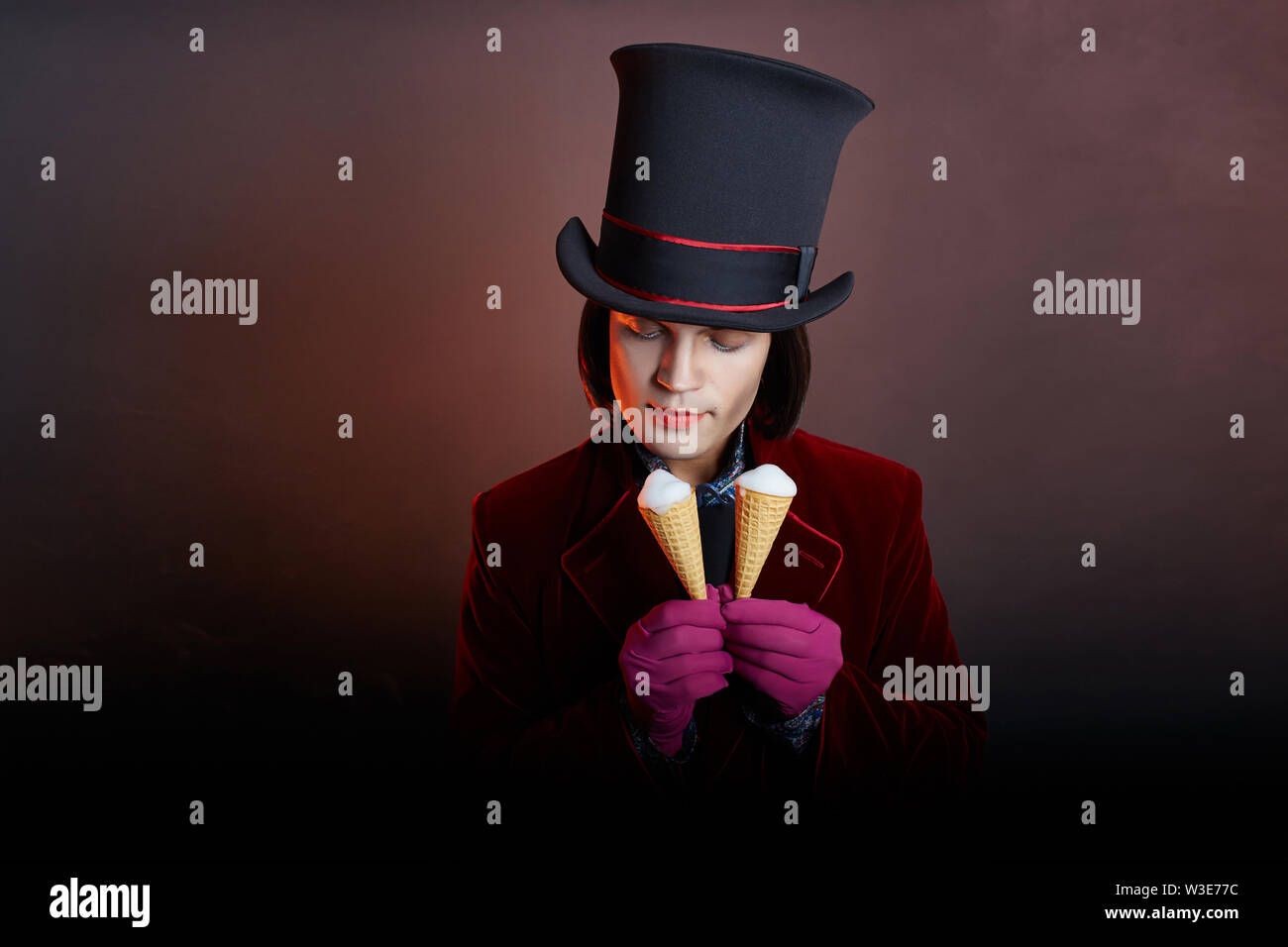 Fabulous circus man in a hat and a red suit posing in the smoke on a ...