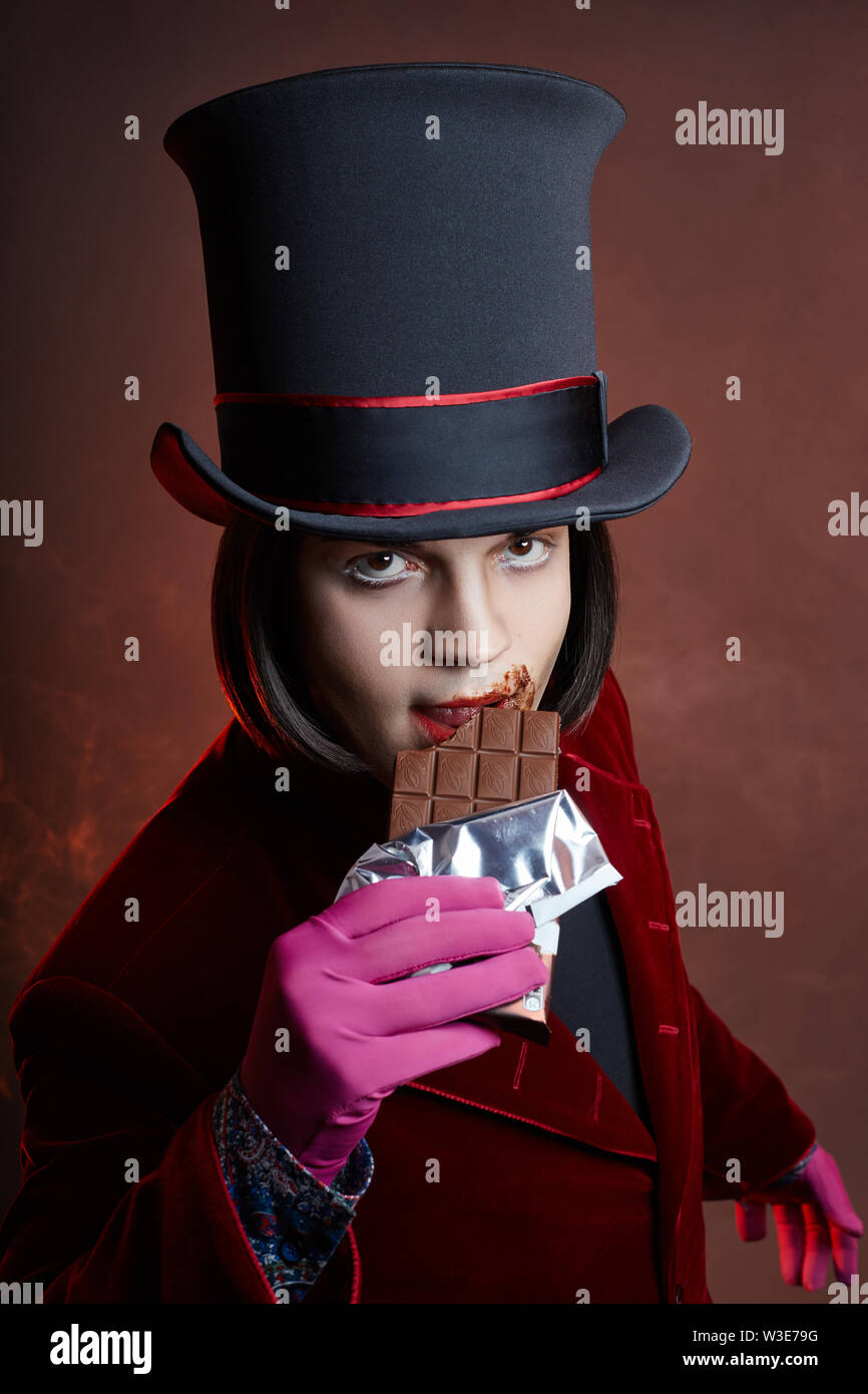 Fabulous circus man in a hat and a red suit posing in the smoke on a ...