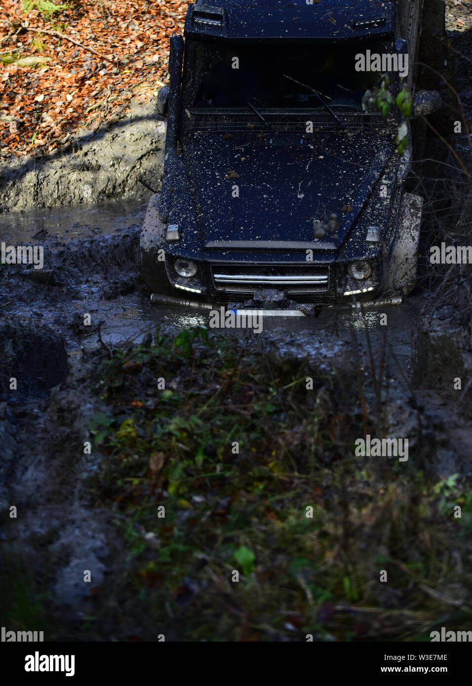 Black crossover driving through dirt with nature on background ...