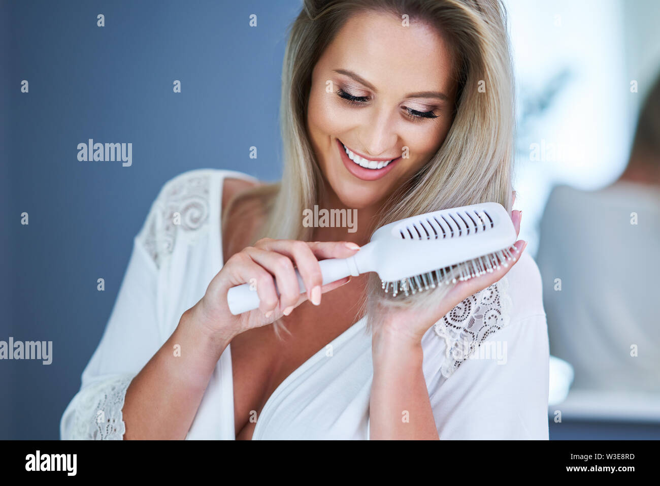 Adult woman brushing her hair in bathroom Stock Photo - Alamy