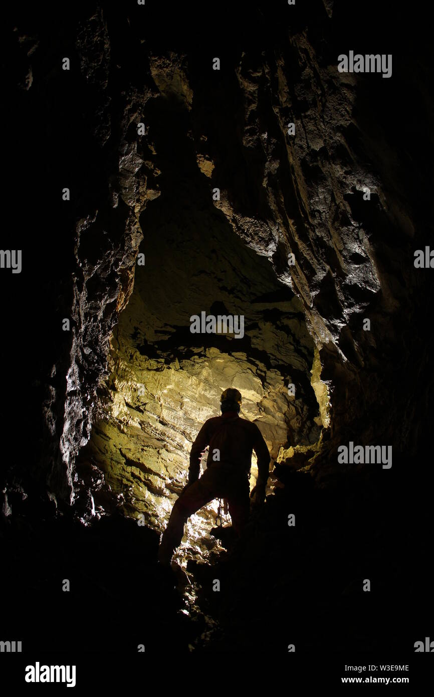 Caver exploring a cave Stock Photo - Alamy