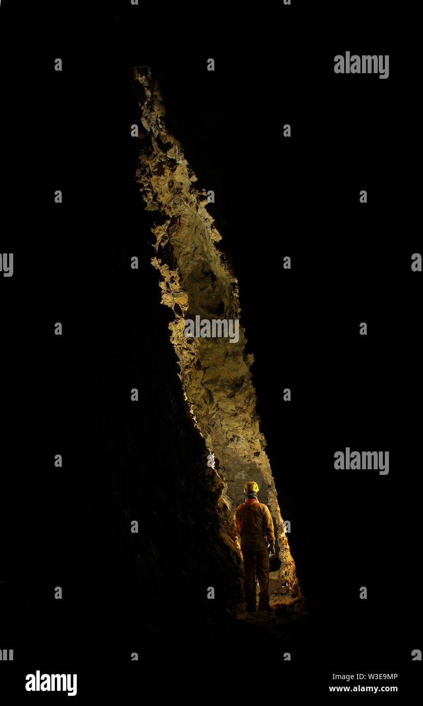 Caver exploring a cave Stock Photo - Alamy