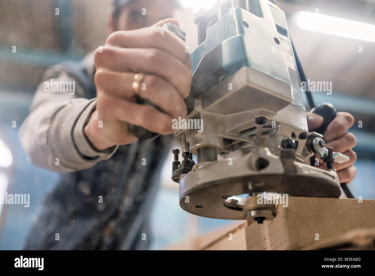 Carpenter using electric woodworking routing a wooden plank Stock Photo ...
