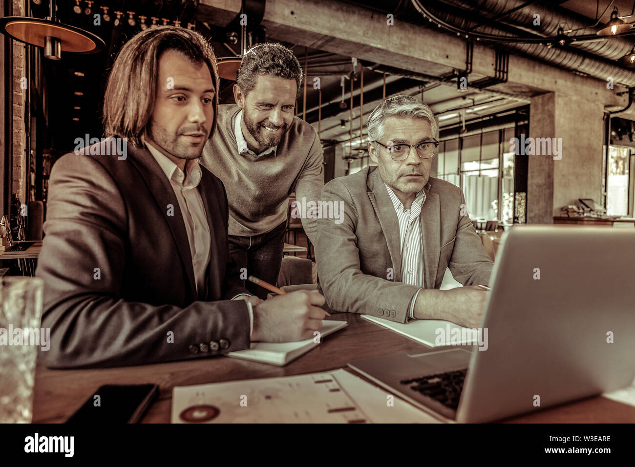 Surprised males staring at screen of computer Stock Photo - Alamy
