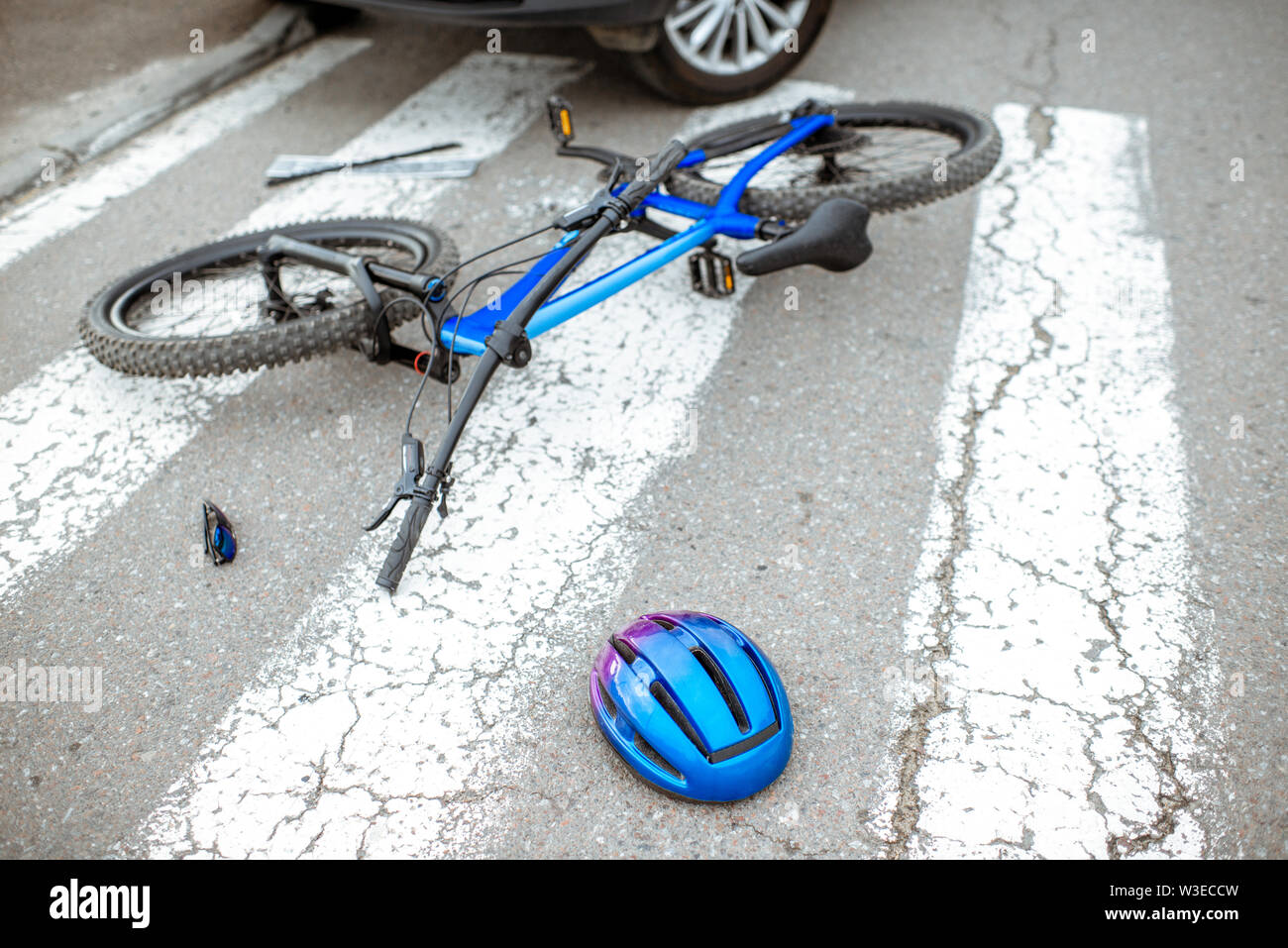 Scene of a road accident with car and broken bicycle lying on the ...