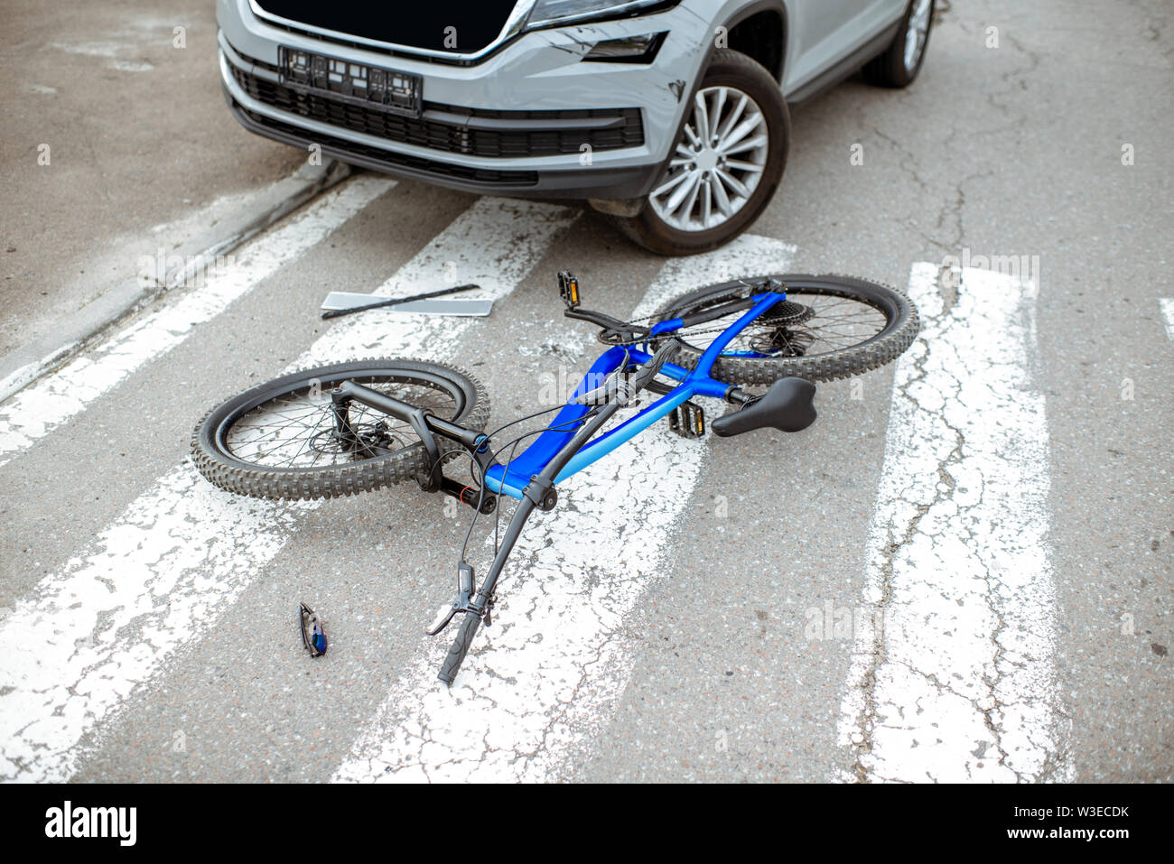 Scene of a road accident with car and broken bicycle lying on the ...