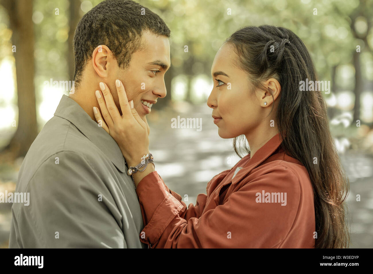 Concentrated resolute woman with dark hair holding face Stock Photo - Alamy