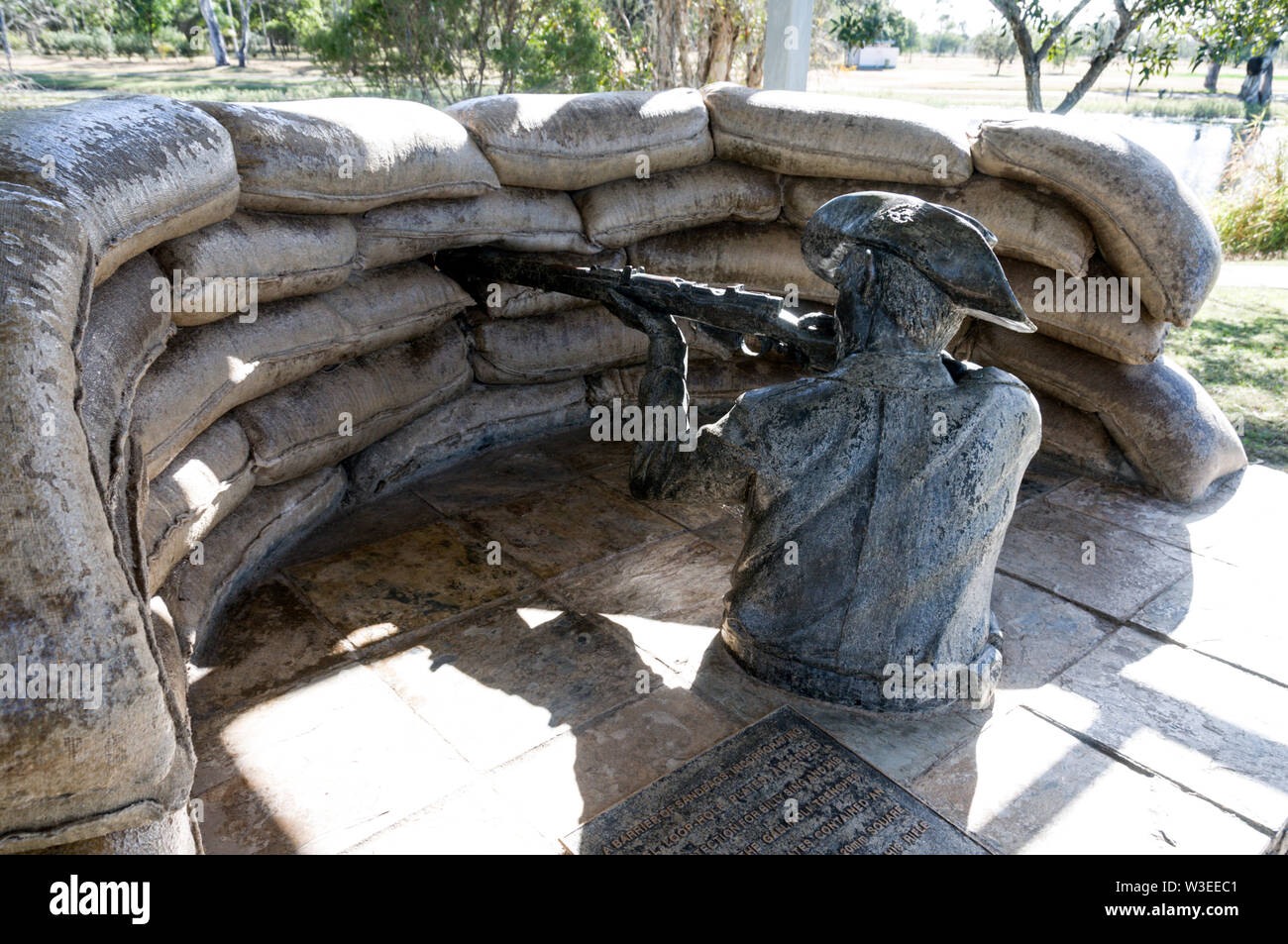 A statue of a 1st World War Australian soldier aiming a rifle behind a ...